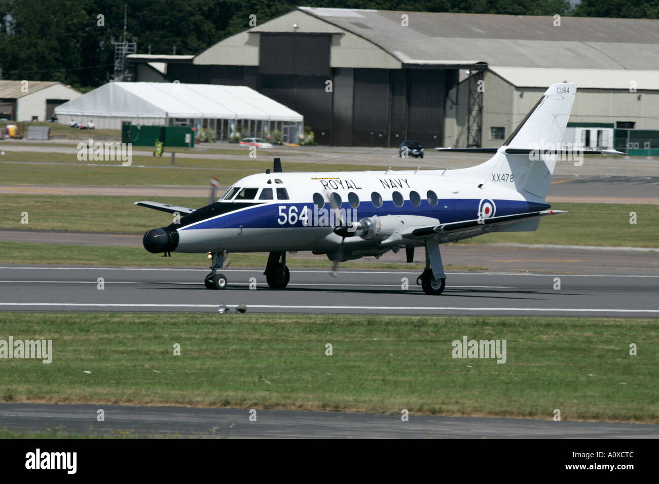 Royal Navy Jetstream T2 lands on airfield runway in front of hangars ...