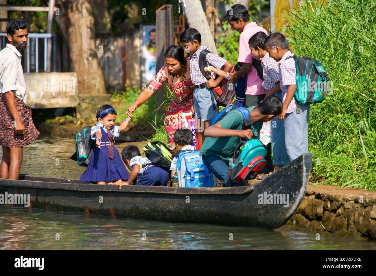 School children boarding a boat in the river, Backwaters, Kerala, India ...