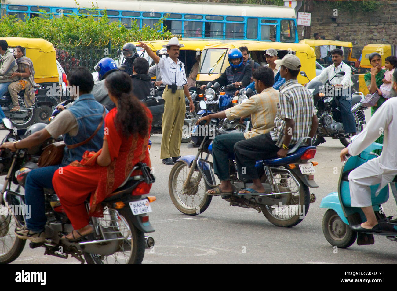 People riding motorcycles and a traffic controller in India Stock Photo ...