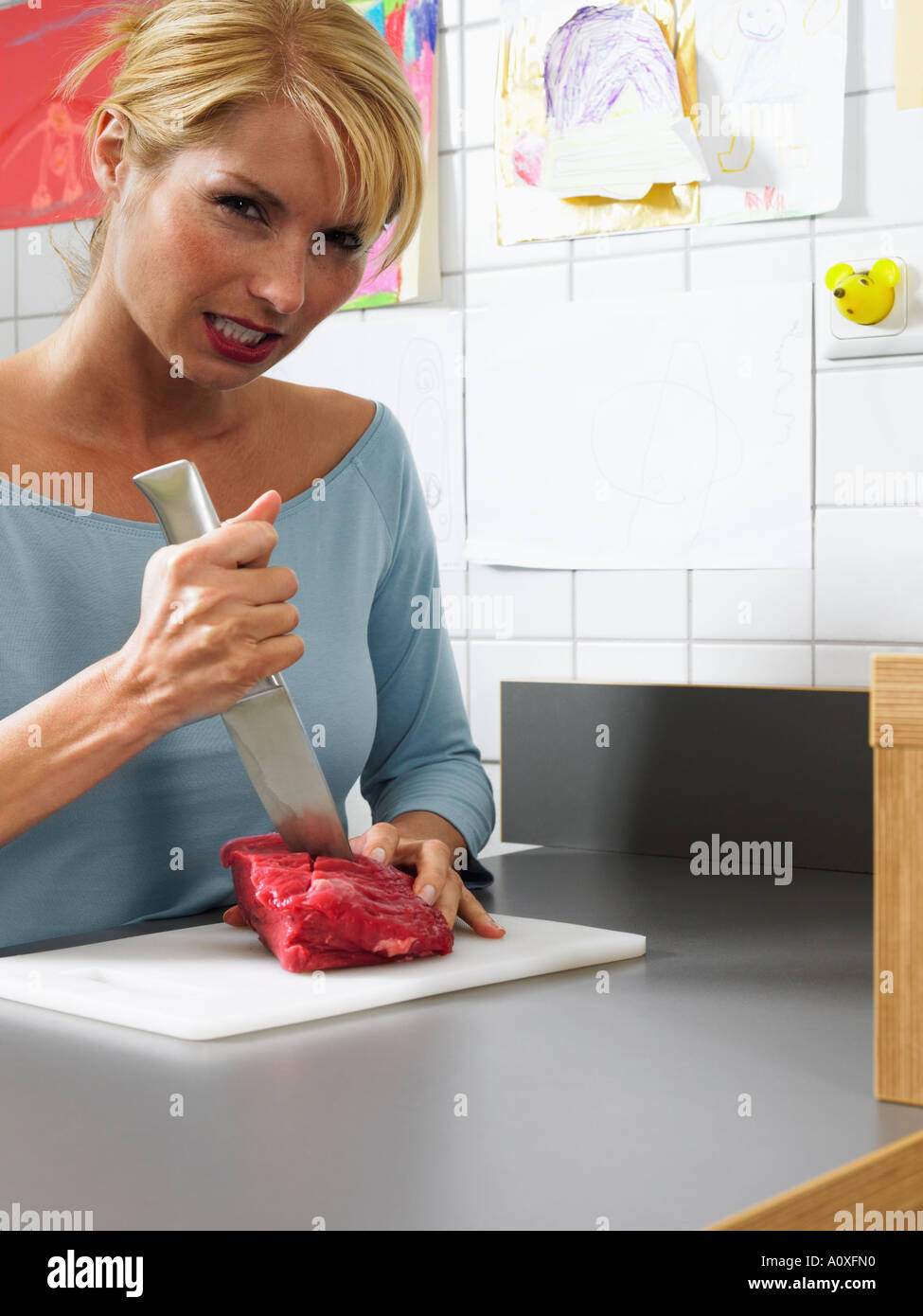 Angry woman cutting beef Stock Photo - Alamy