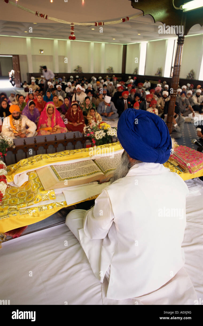 Sikh priest and holy book at Sikh wedding London England United Kingdom ...