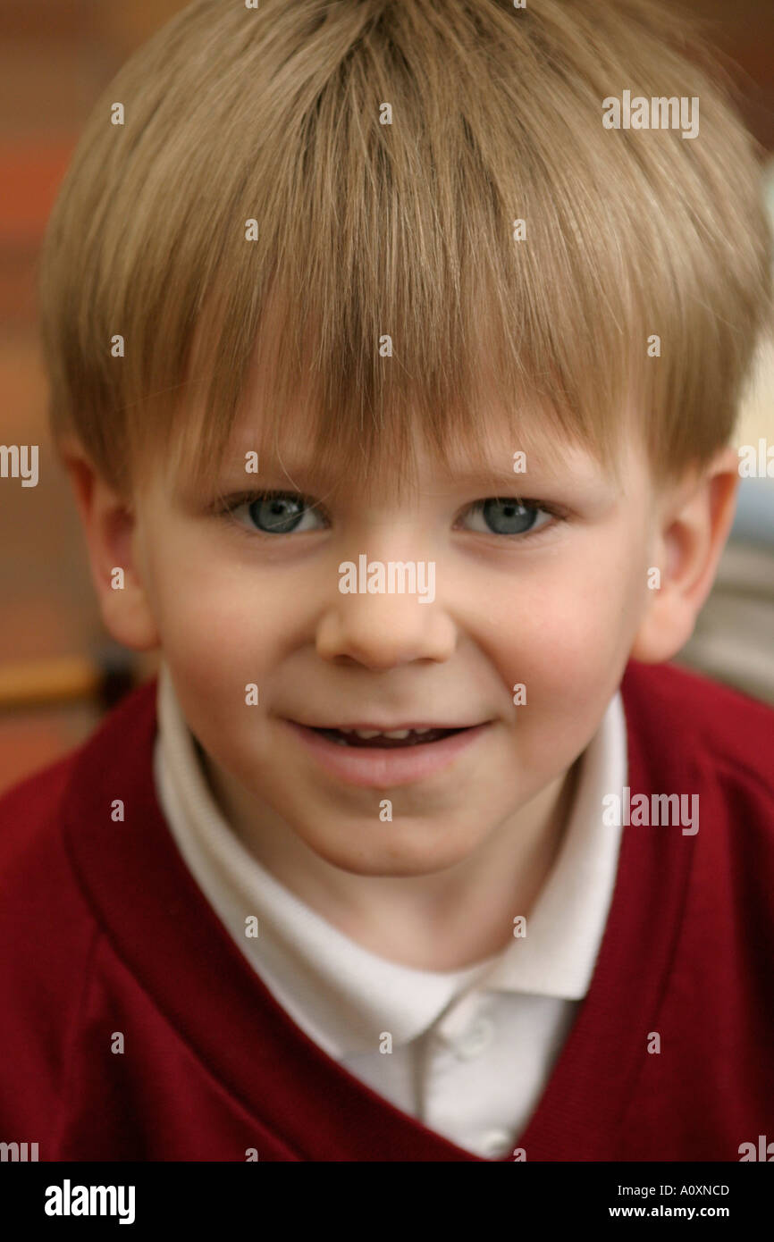 Close up of Four year old boy in school uniform looking into camera ...