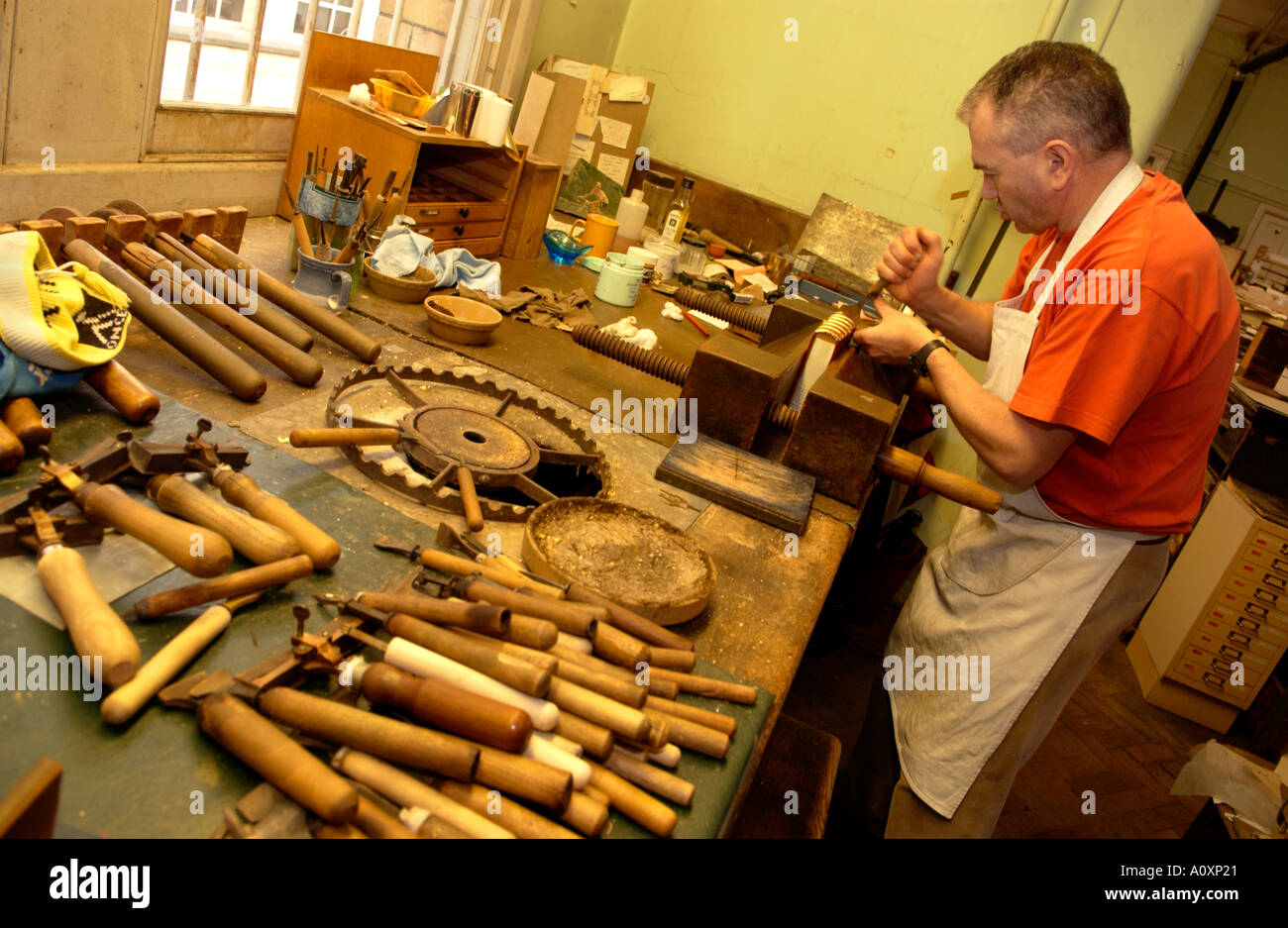 Craftsman guilding a book at the George Bayntun book bindery Bath ...