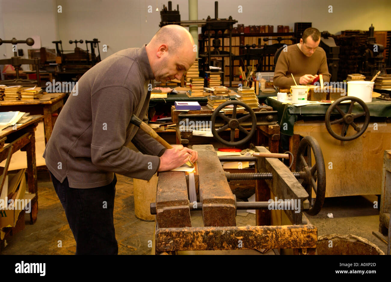 Craftsman guilding the page edges of a book at the George Bayntun book ...