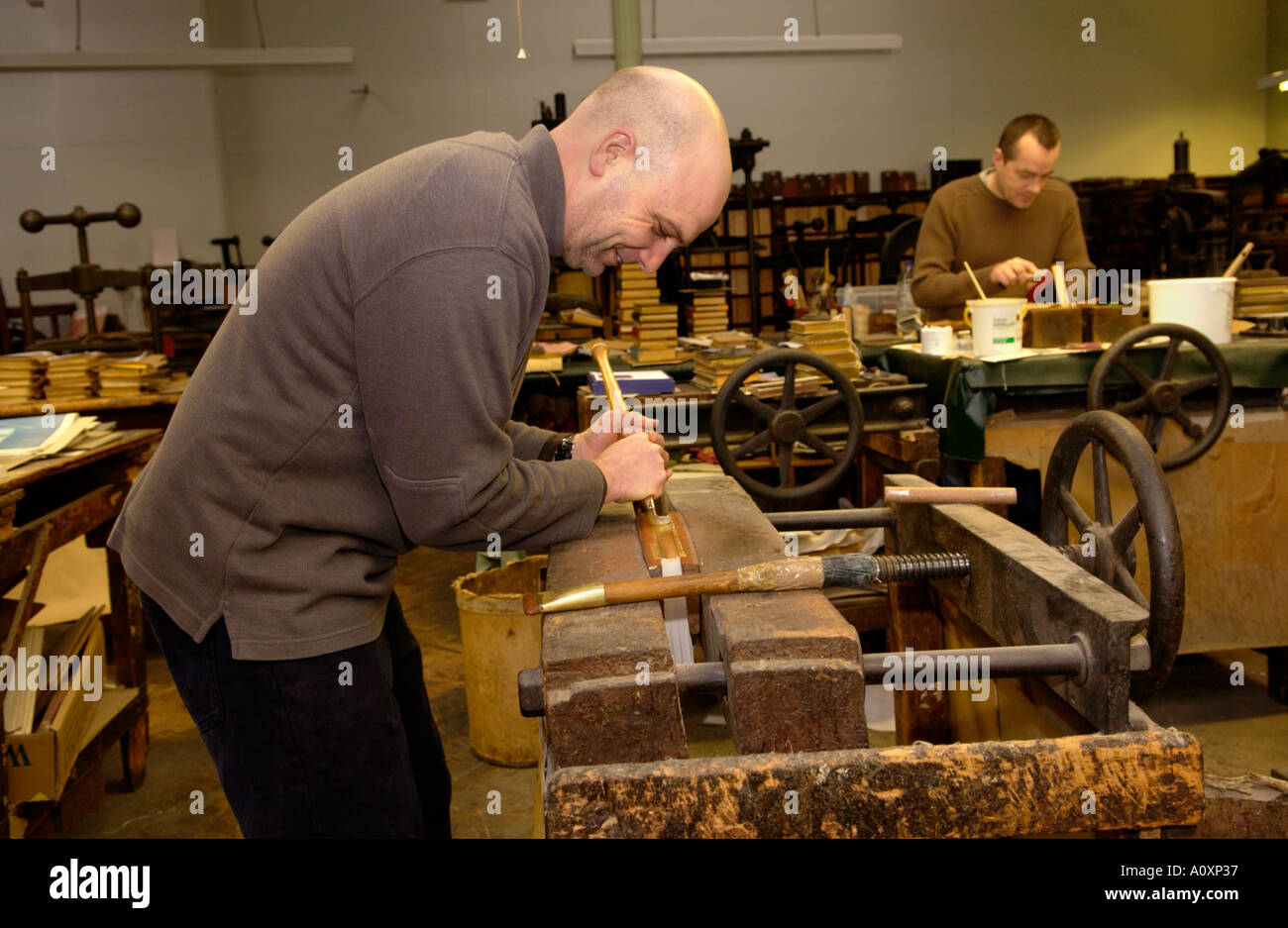 Craftsman guilding the page edges of a book at the George Bayntun book ...