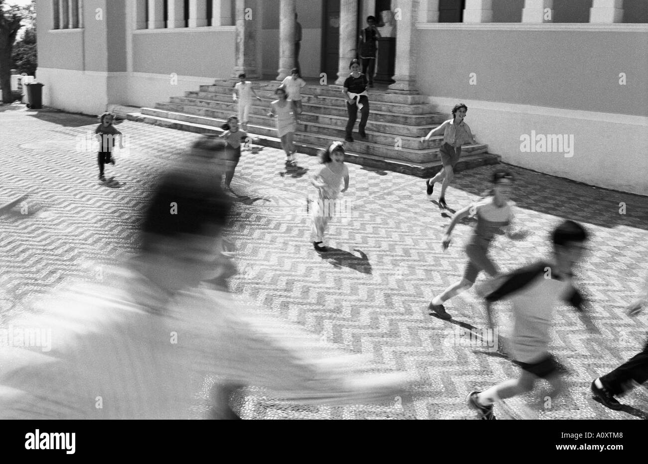 GREECE KASTELLORIZO ISLAND Children playing chase in school playground ...