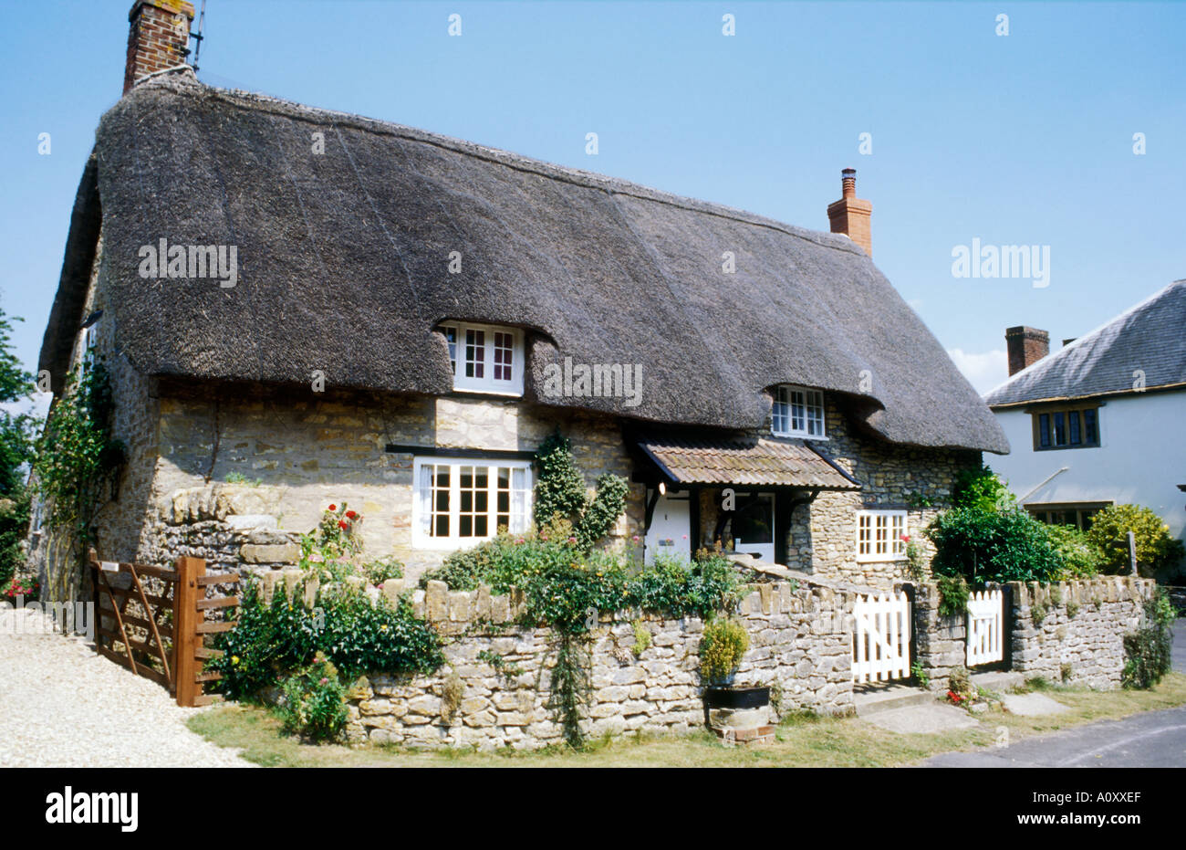 A traditional old English thatched roof Cottage set in a rural village ...