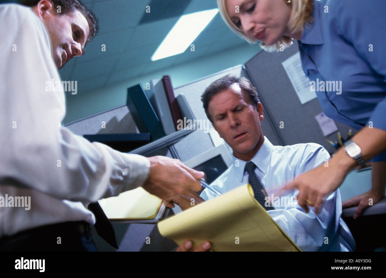 Low angle view of a businesswoman and two businessmen talking Stock ...