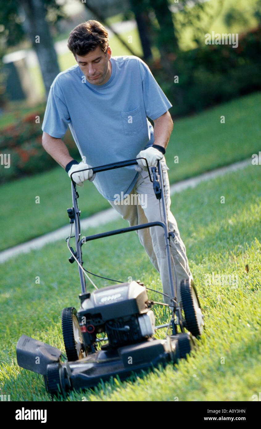 Young man mowing the lawn Stock Photo - Alamy