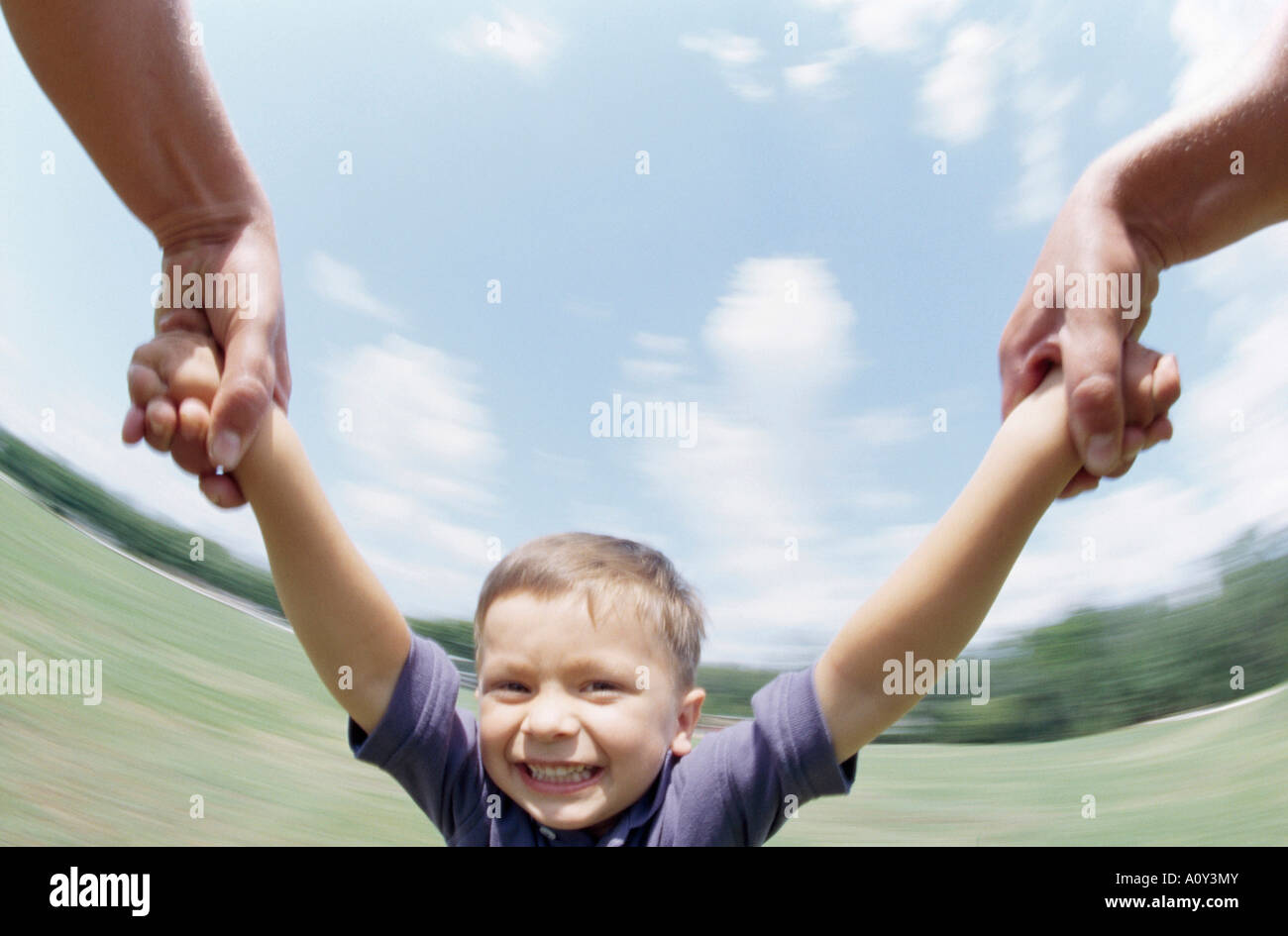 Person's hands swinging a boy Stock Photo - Alamy