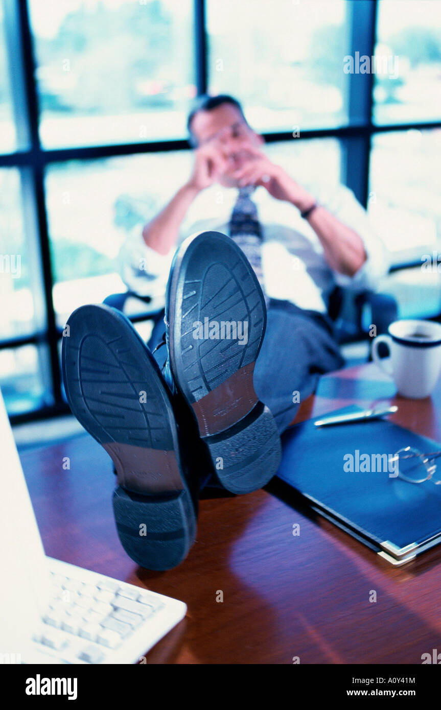 Businessman with his feet up on a desk Stock Photo - Alamy