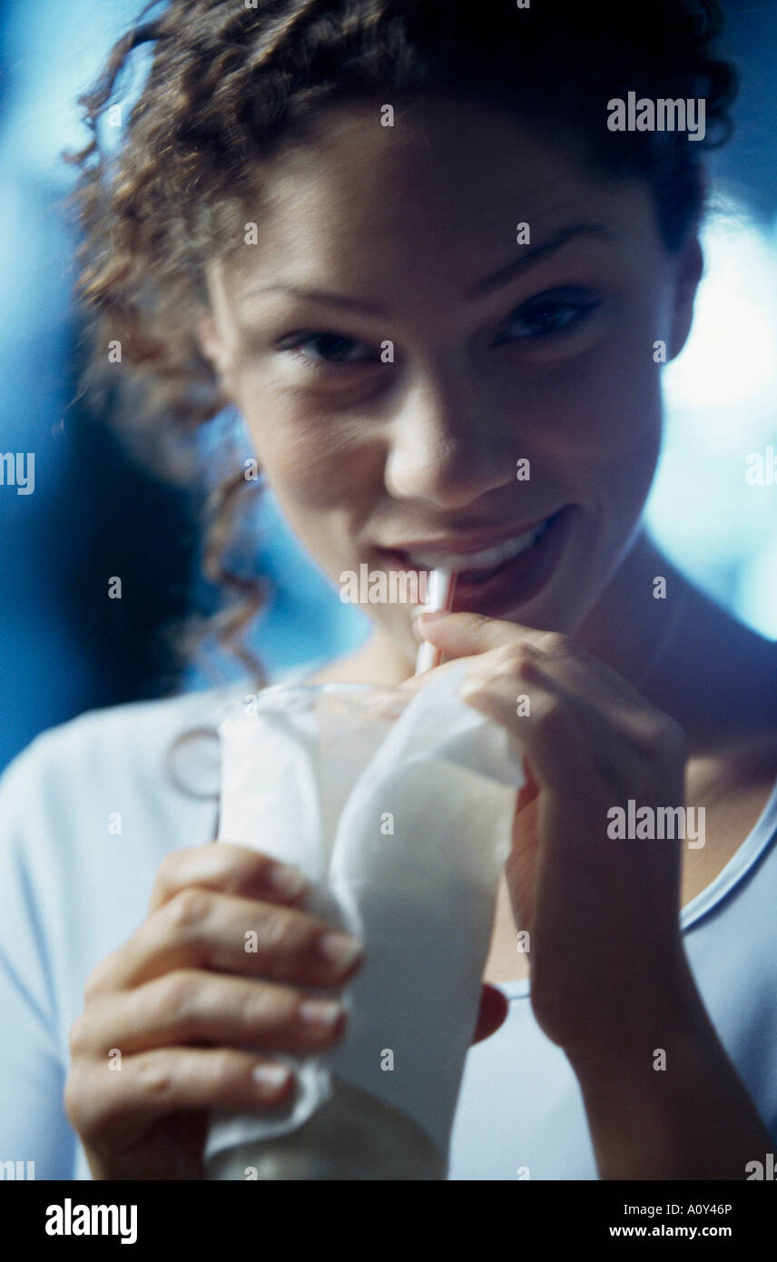 Portrait of a young woman sipping a milkshake Stock Photo - Alamy