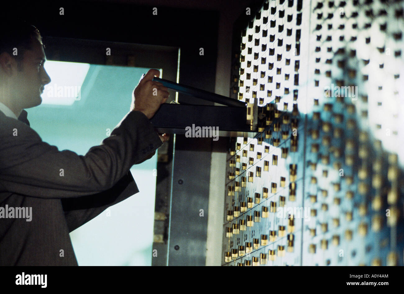 Side profile of a man pulling out a safety deposit box Stock Photo - Alamy