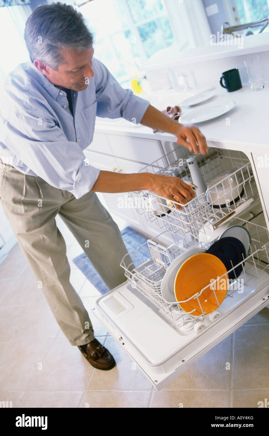 High angle view of a mid adult man loading the dishwasher Stock Photo ...