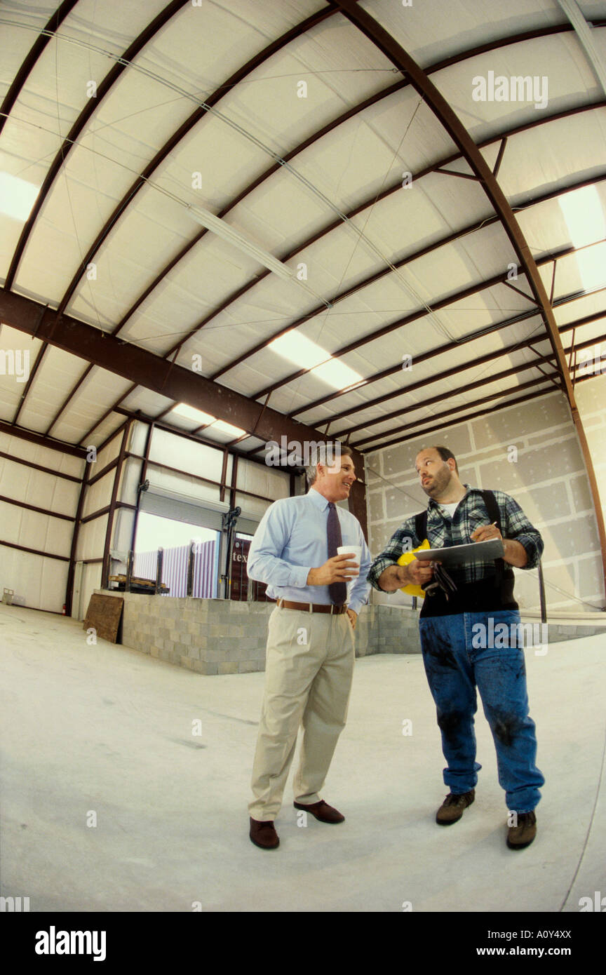 Low angle view of two mature men standing in a warehouse Stock Photo ...