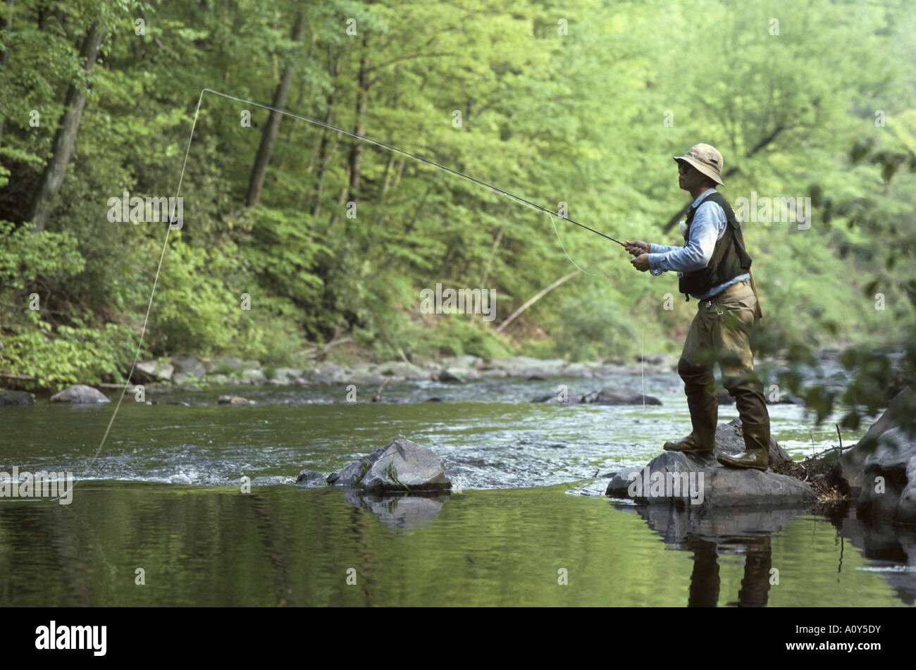 Side profile of a man fishing in a river Stock Photo - Alamy