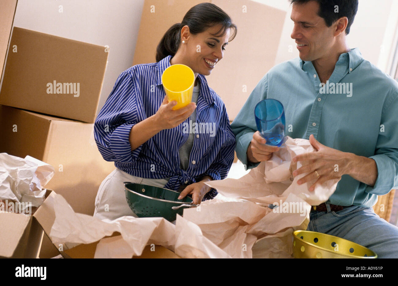 Young couple unpacking goods in a house Stock Photo - Alamy