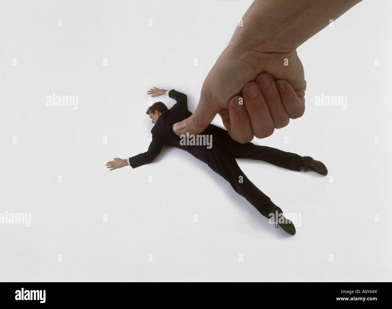 Businessman under a person's thumb Stock Photo - Alamy