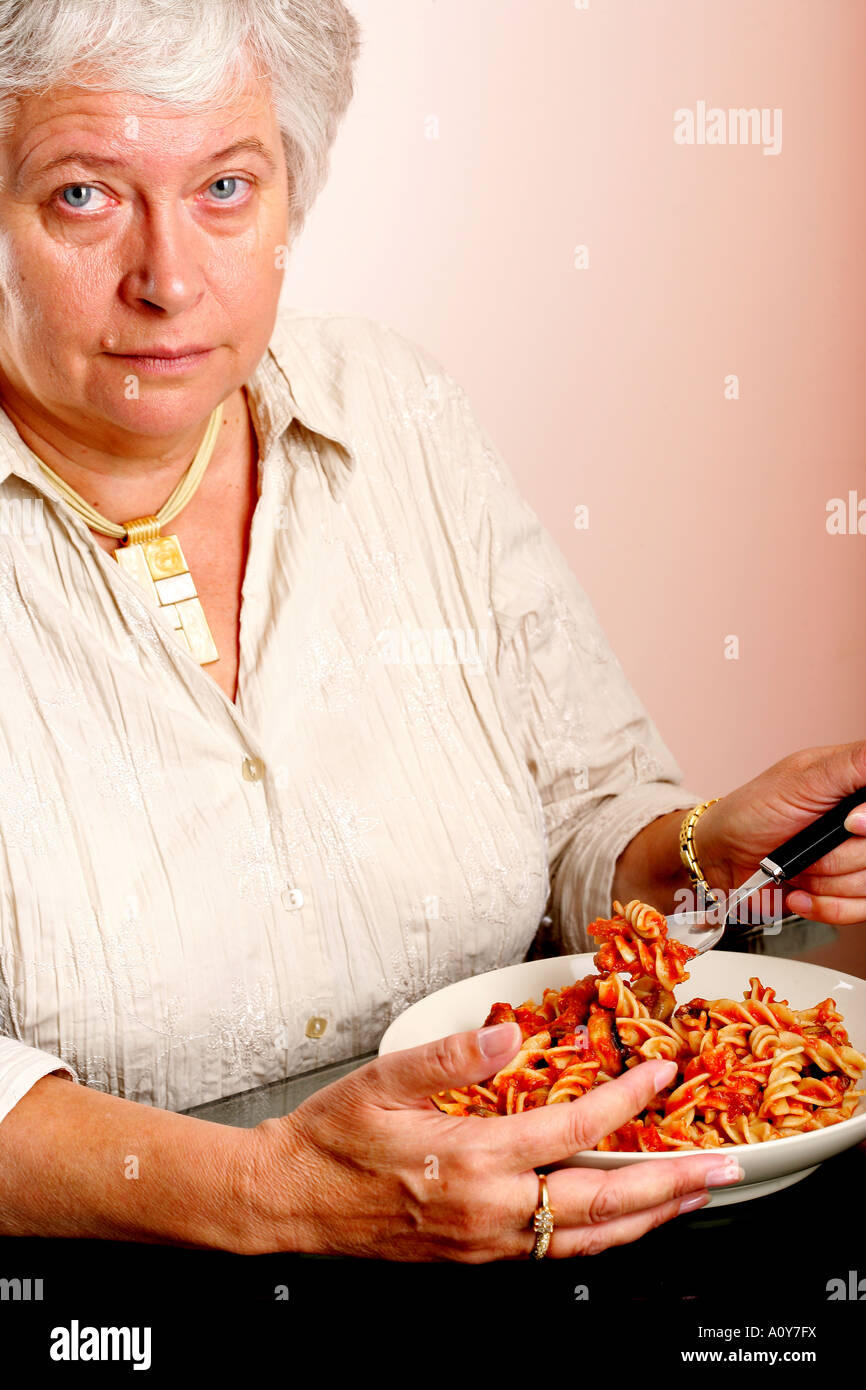 Middle aged woman eating pasta hi-res stock photography and images - Alamy