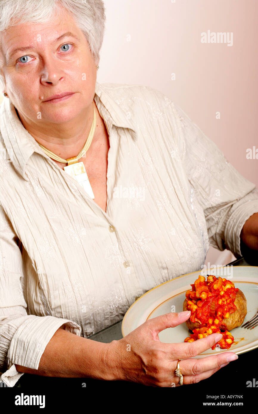 Mature Woman Eating Jacket Potato with Spicy Chickpeas Model Released ...