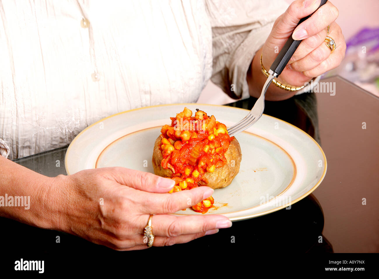 Mature Woman Eating Jacket Potato with Spicy Chickpeas Model Released ...
