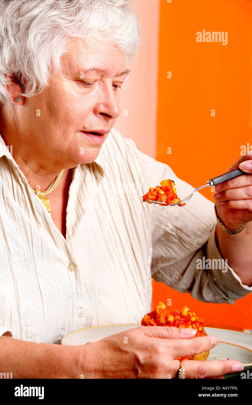 Mature Woman Eating Jacket Potato with Spicy Chickpeas Model Released ...