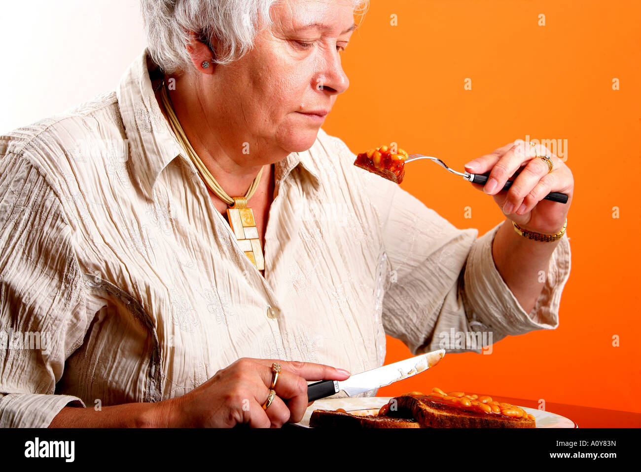Mature Woman Eating Beans on Toast Model Released Stock Photo - Alamy