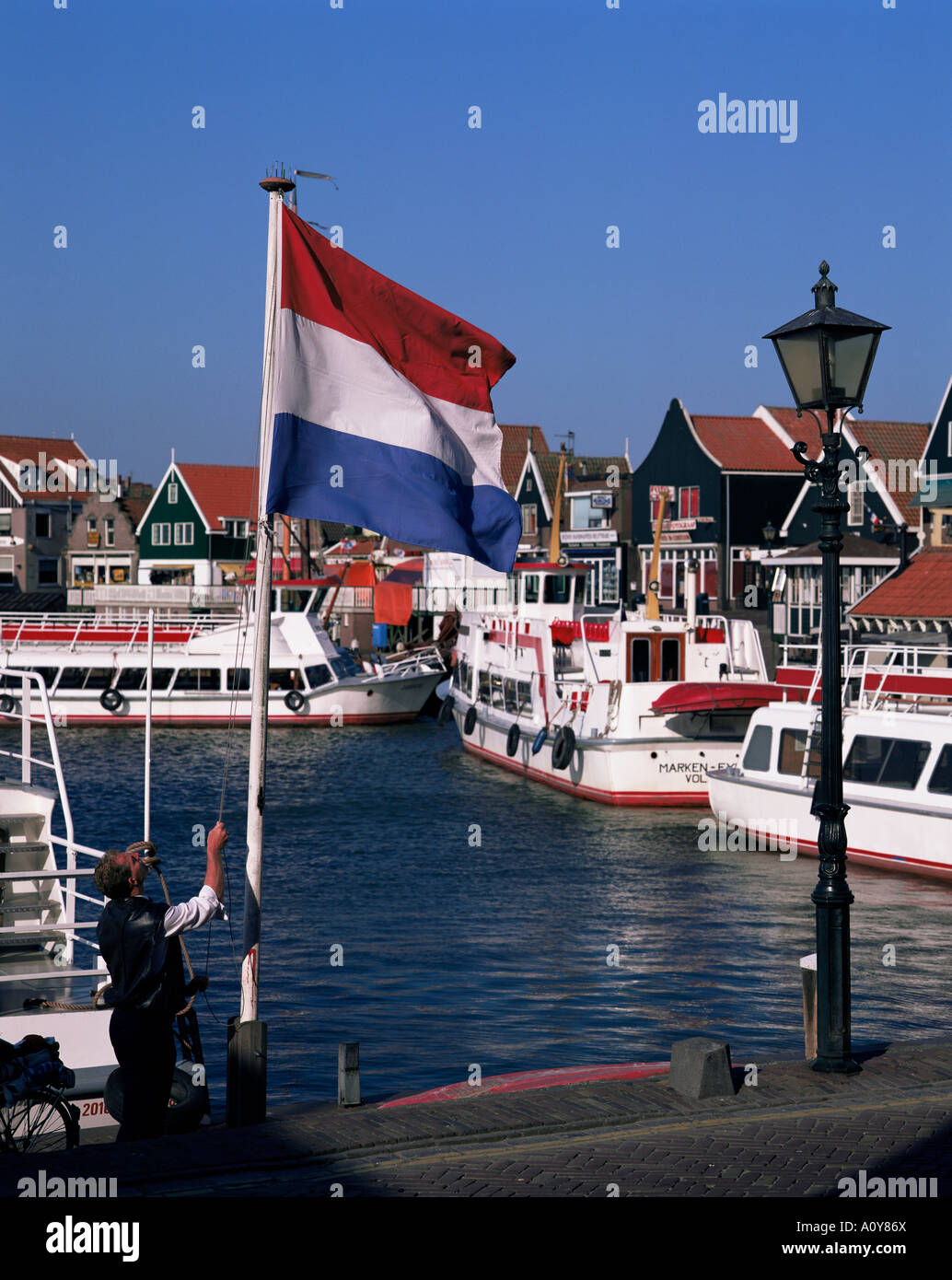 Raising the Dutch flag by the harbour Volendam IJsselmeer Holland ...