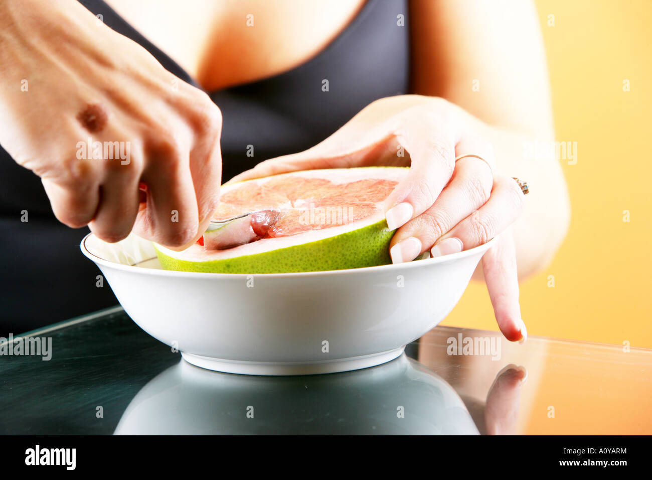 Young Woman Eating Half A Healthy Ripe Pink Breakfast Grapefruit From A ...