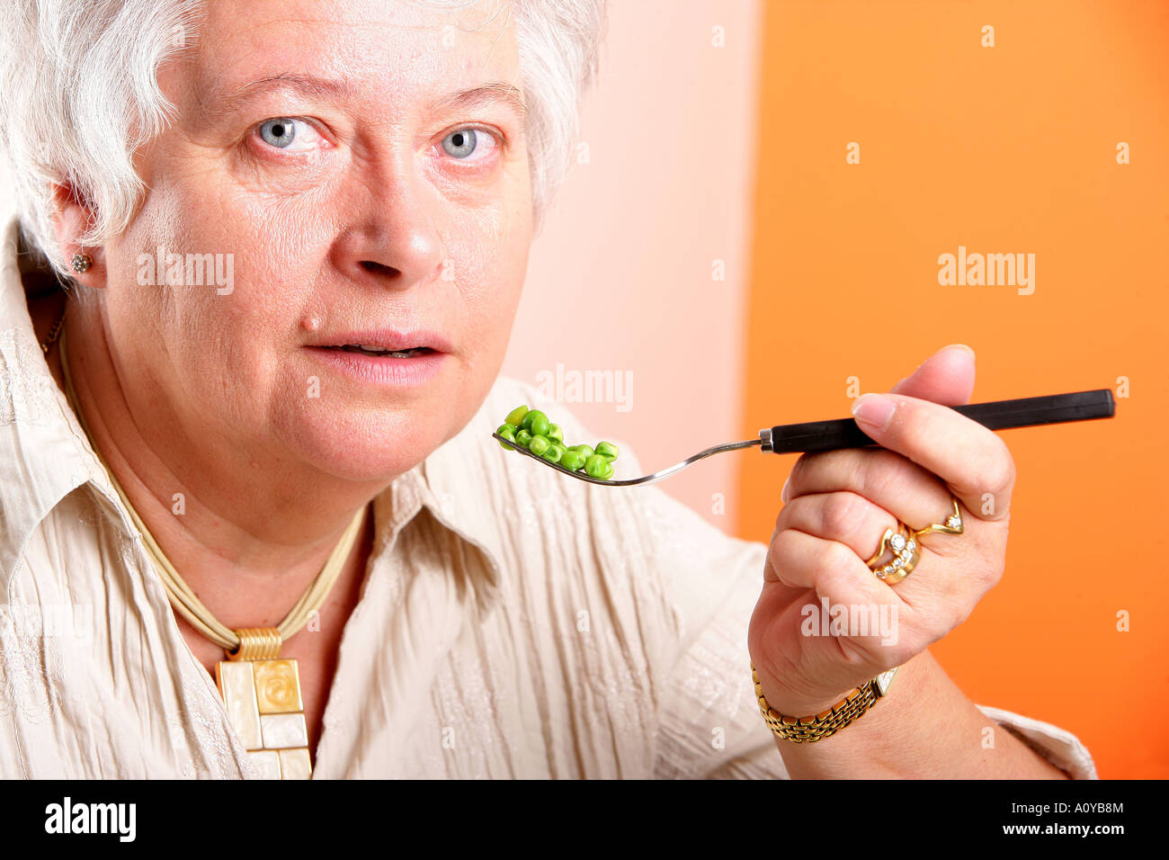 Mature Woman Eating Peas Model Released Stock Photo - Alamy