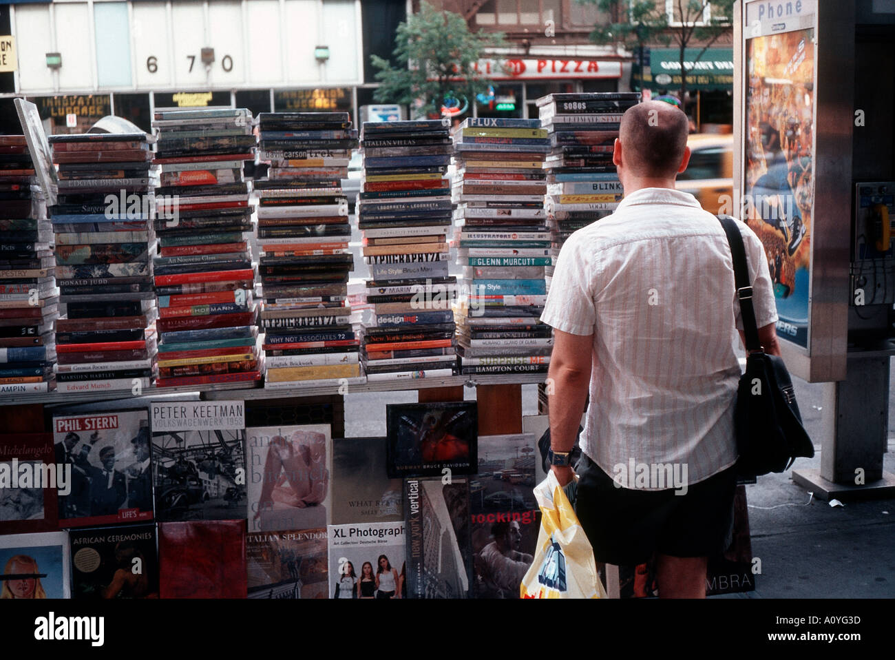 A man browses a display of books set up by a street vendor on Sixth ...
