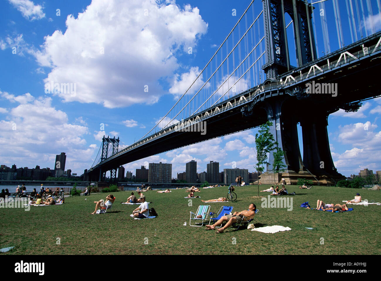 People sunbathing at a park in Brooklyn under the Manhattan Bridge New ...