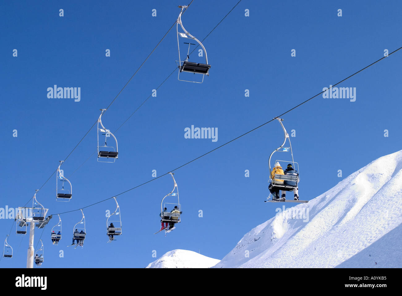 Skiers on chair lift France Stock Photo - Alamy