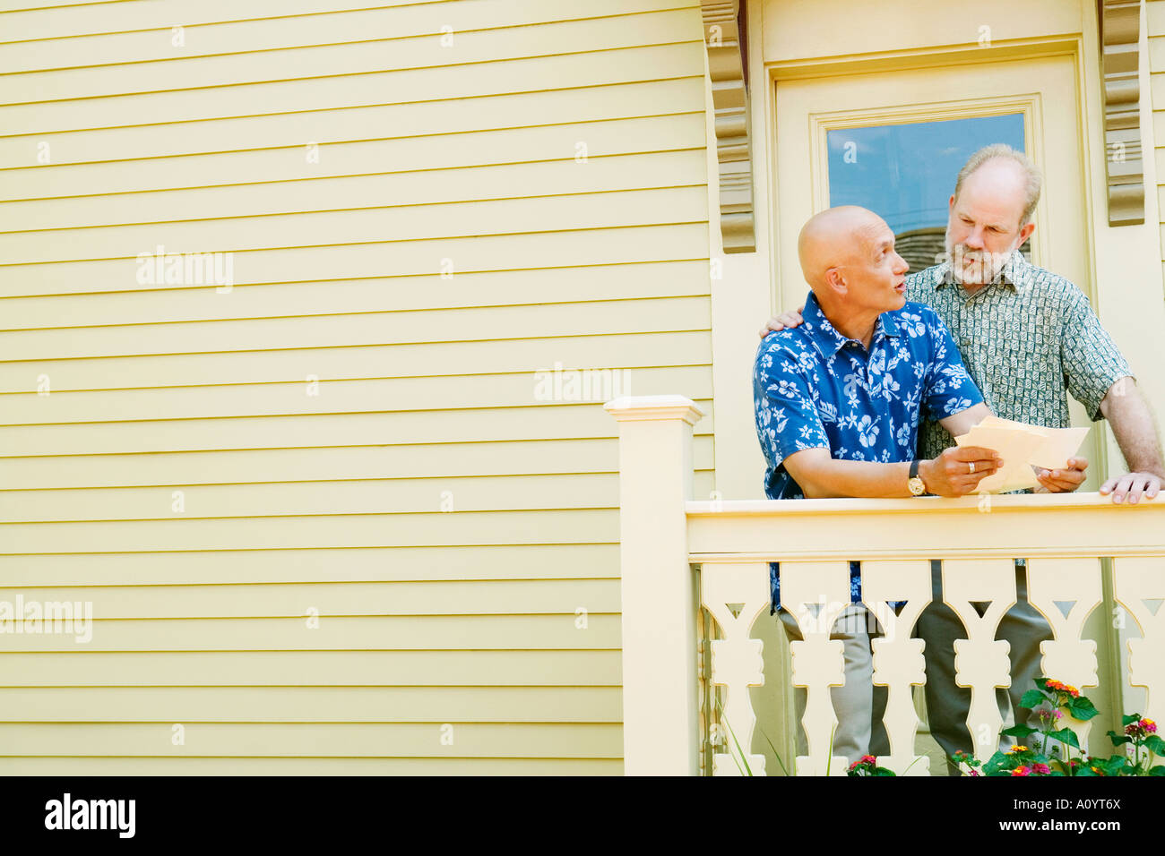 Couple reading their mail on porch Stock Photo - Alamy