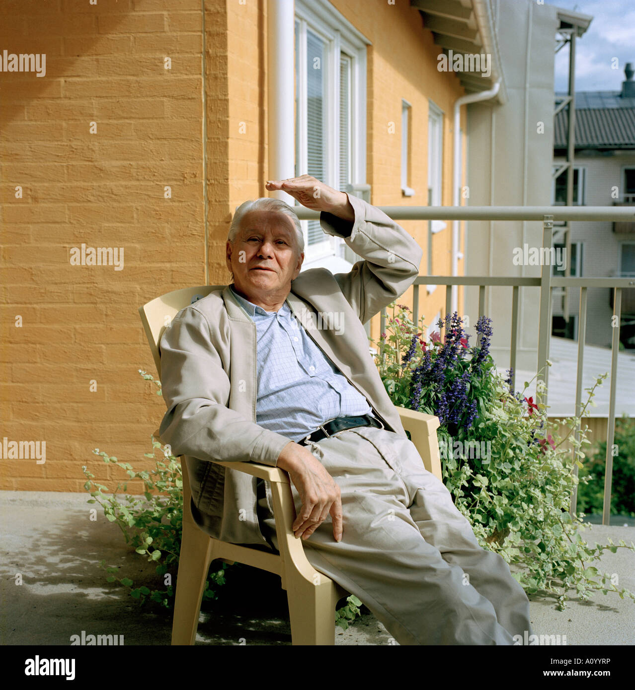 Demented an old, but strong- willed man sitting in a chair on a balcony ...
