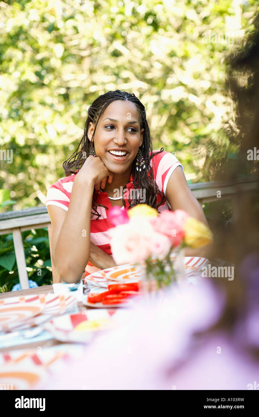 Young African woman sitting at the table outdoors Stock Photo - Alamy