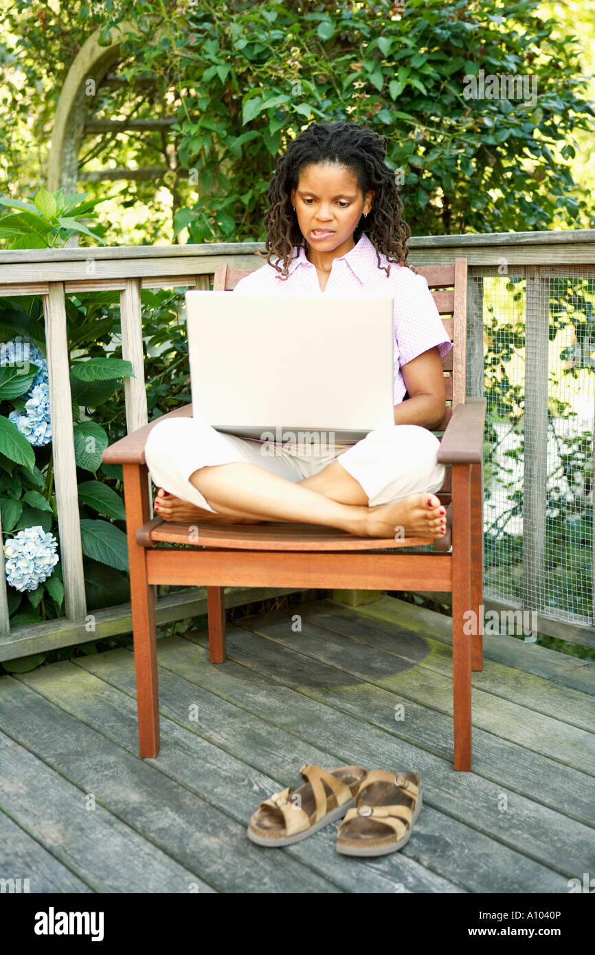 Young African woman using a laptop outdoors Stock Photo - Alamy