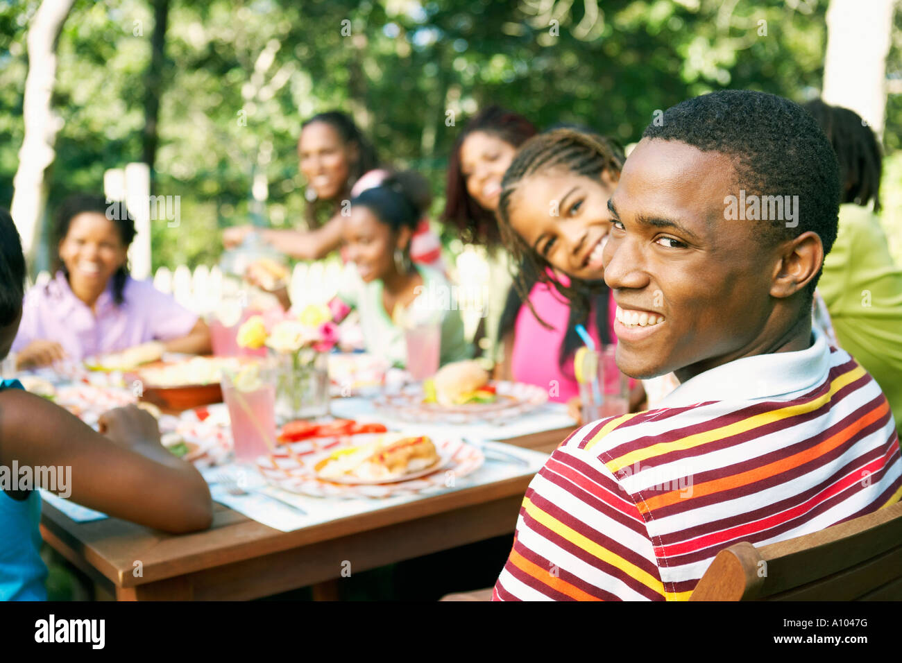 Young African man eating with his family outdoors Stock Photo - Alamy