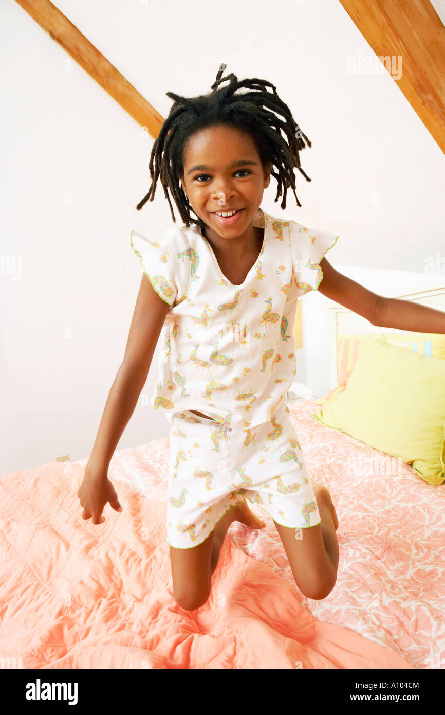 Young African girl jumping on the bed Stock Photo - Alamy