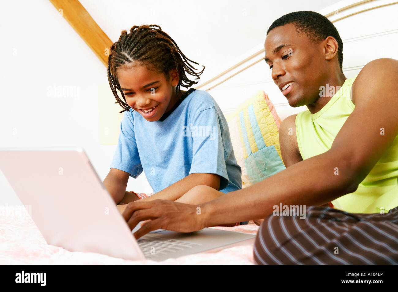 Young African boy using a laptop with his father Stock Photo - Alamy