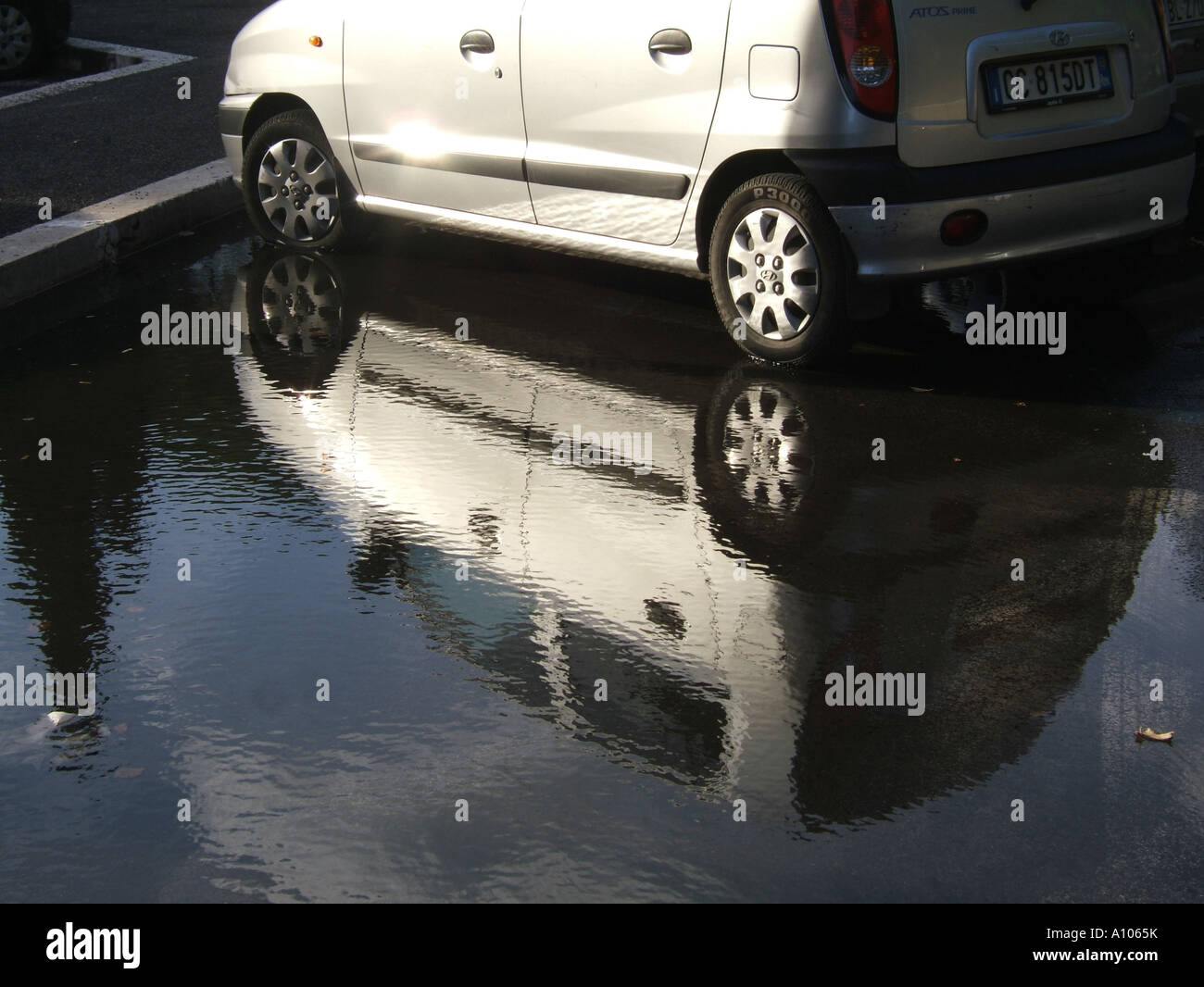 silver parked car reflection on flooded road Stock Photo - Alamy