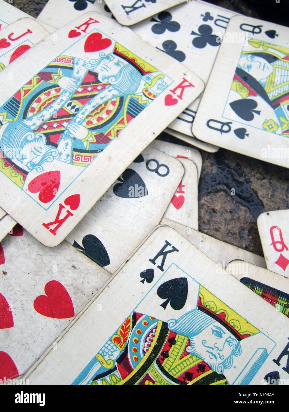 playing cards discarded on wet road Stock Photo - Alamy
