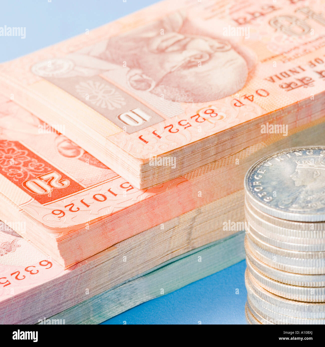 Close-up of Indian banknotes with a stack of Indian silver coins Stock ...
