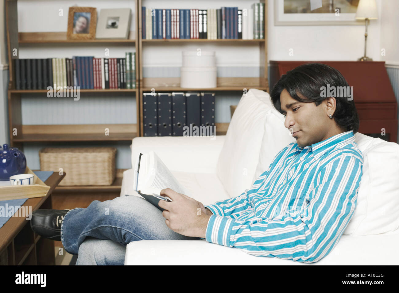 Side profile of a young man reading a book Stock Photo - Alamy