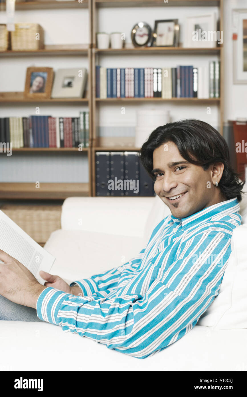 Side profile of a young man sitting on a couch and smiling Stock Photo ...