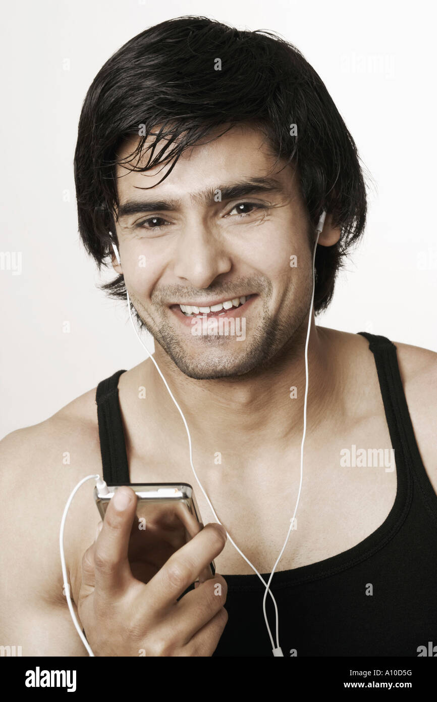 Portrait of a young man listening to an MP3 player Stock Photo - Alamy