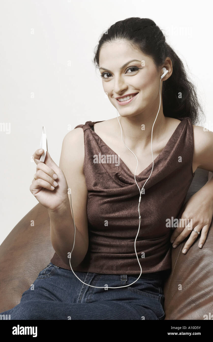 Portrait of a young woman listening to an MP3 player Stock Photo - Alamy