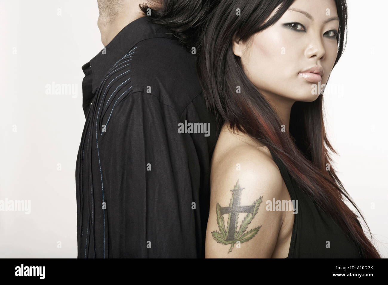 Side profile of a young couple standing back to back Stock Photo - Alamy