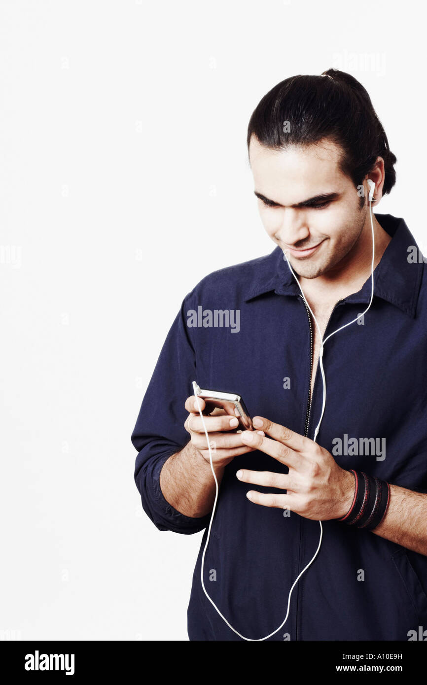 Young man listening to an MP3 player Stock Photo - Alamy