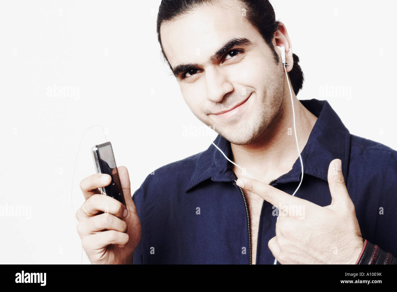 Portrait of a young man listening to an MP3 player Stock Photo - Alamy